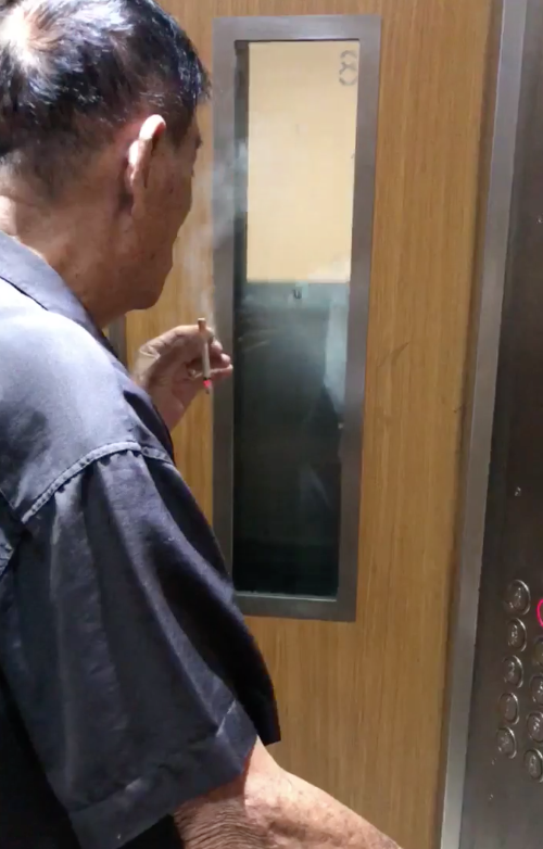 Elderly man takes long drag on cigarette in Teban Gardens HDB lift as ...