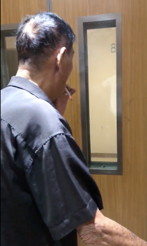 Elderly man takes long drag on cigarette in Teban Gardens HDB lift as ...
