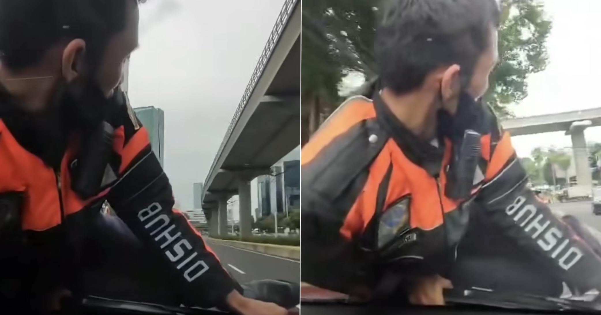 Indonesian traffic officer clings onto hood of car as driver speeds off ...
